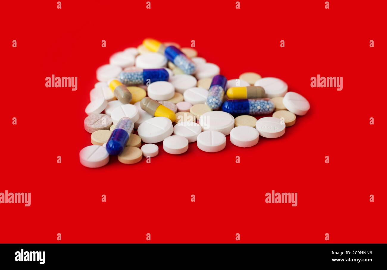 Heap of colorful pills in the shape of a heart, tablets and capsules ...