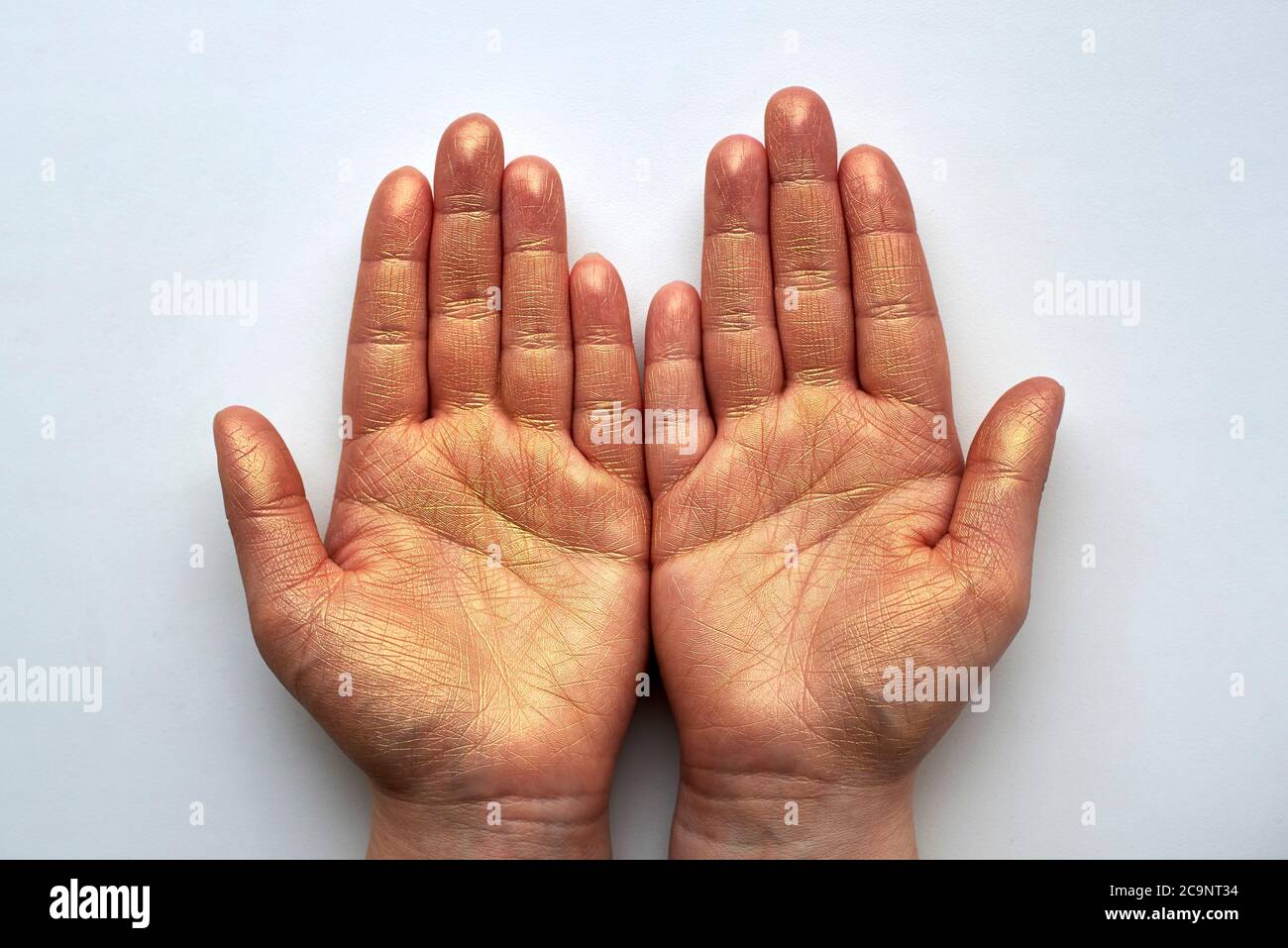 Palms of a girl with golden glitter on a white background. Hands of ...