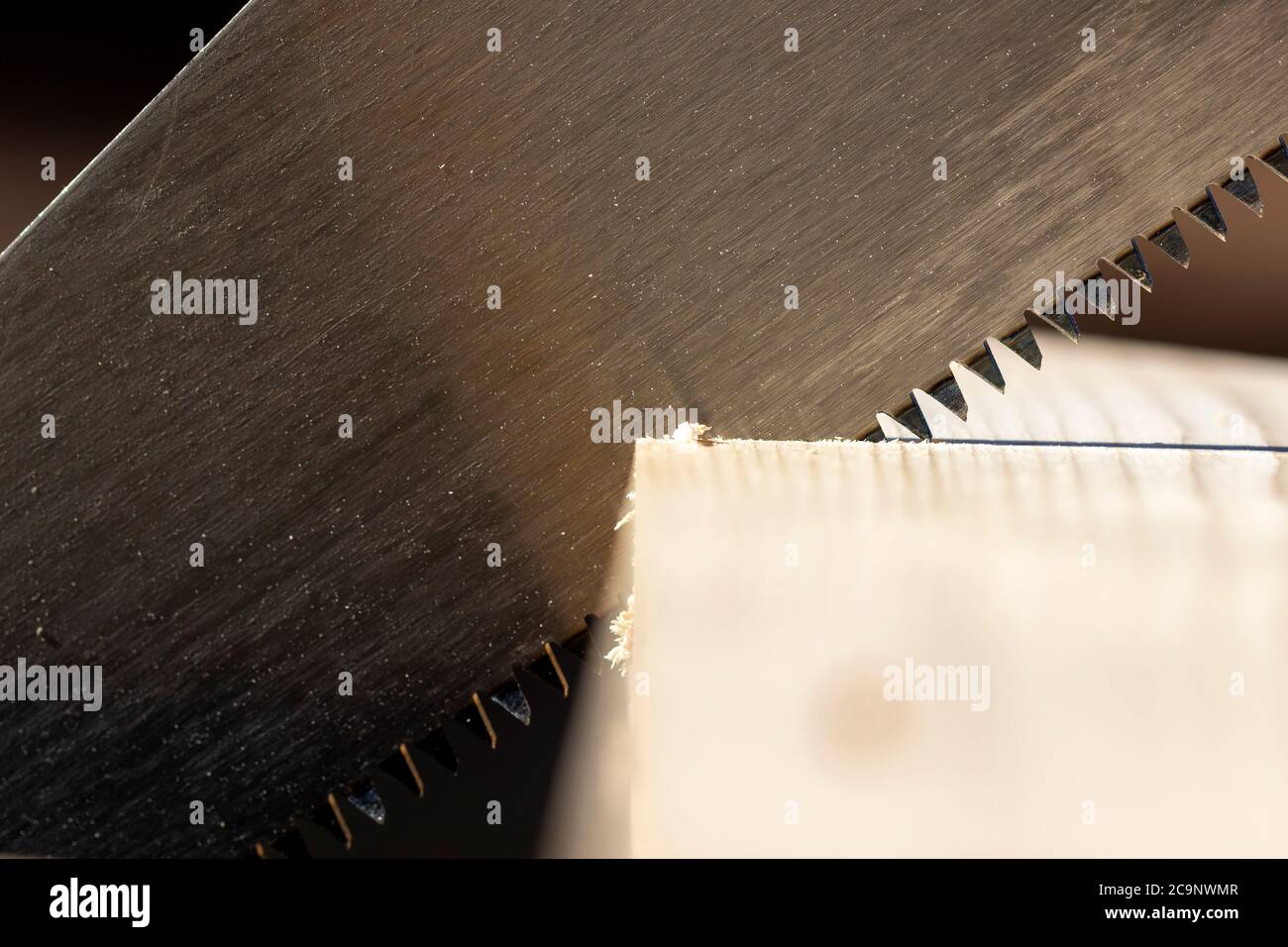 A closeup portrait of a wooden plank being sawn by a wood cutting hand ...