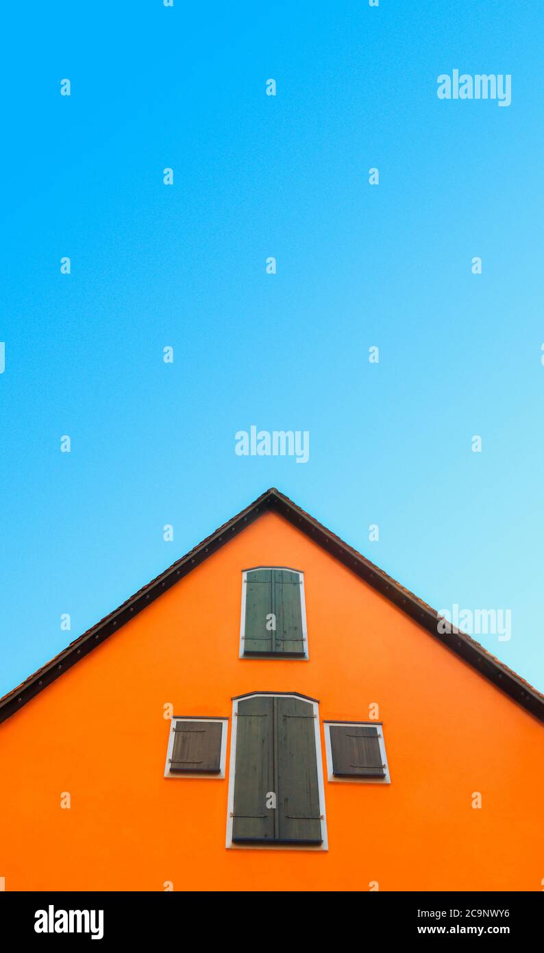Orange house isolated on a blue sky. German home with orange walls and ...