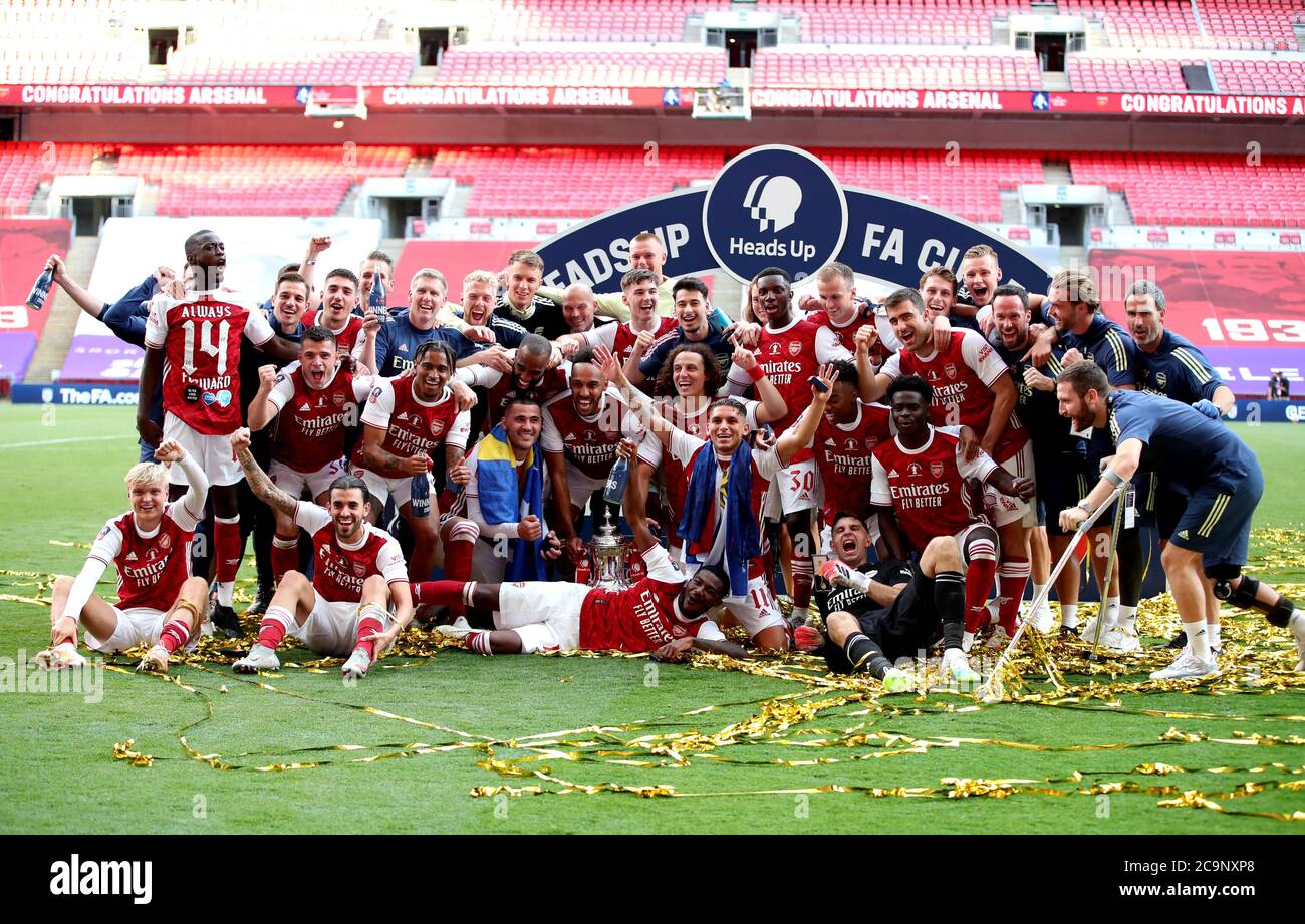 Arsenal players and staff celebrate with the trophy after winning the ...