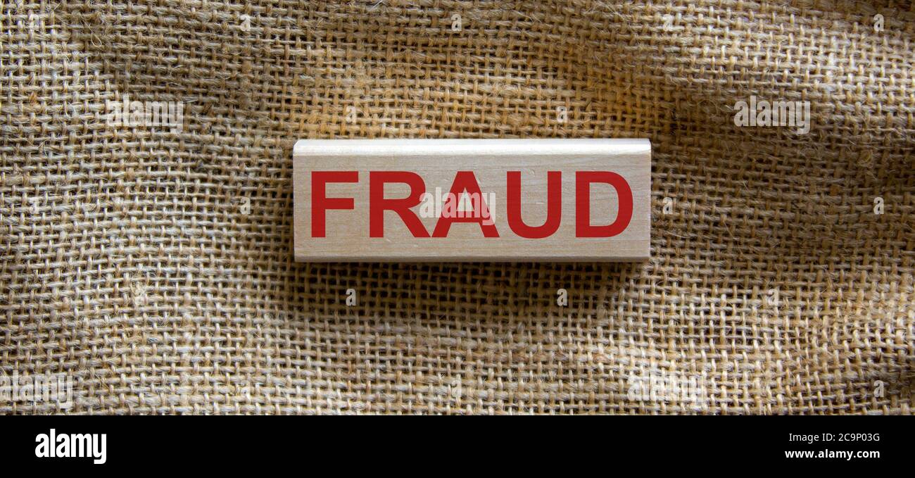 Wooden blocks form the word 'fraud' on beautiful canvas background ...