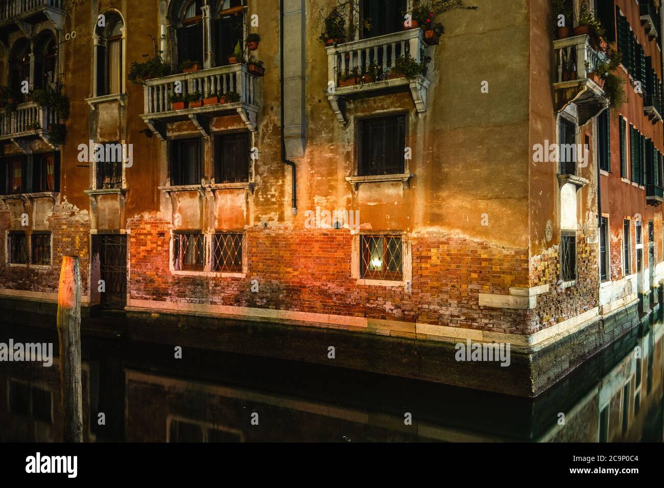 Orange building by a small canal in Venice at night, Italy Stock Photo ...