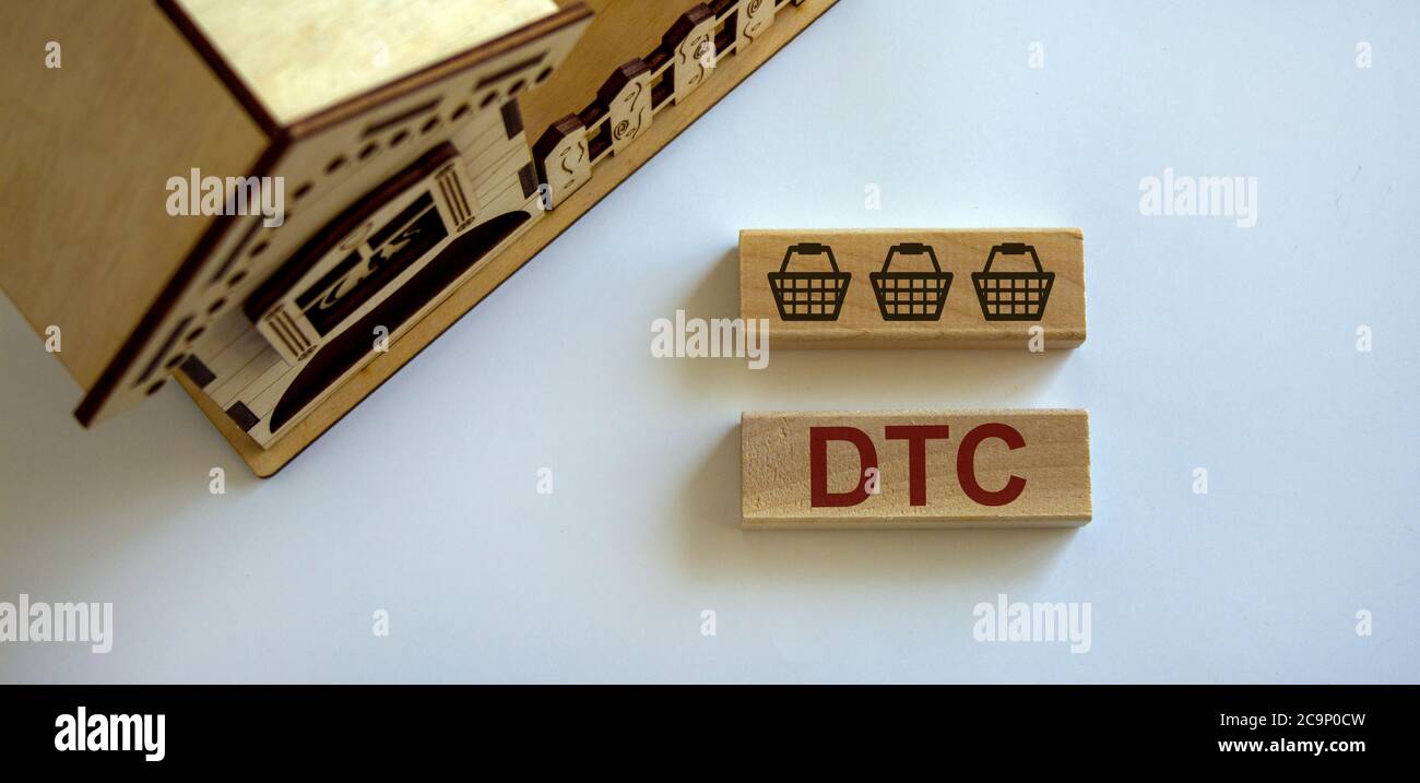 Wooden block form the word 'DTC' and food basket icon near miniature ...