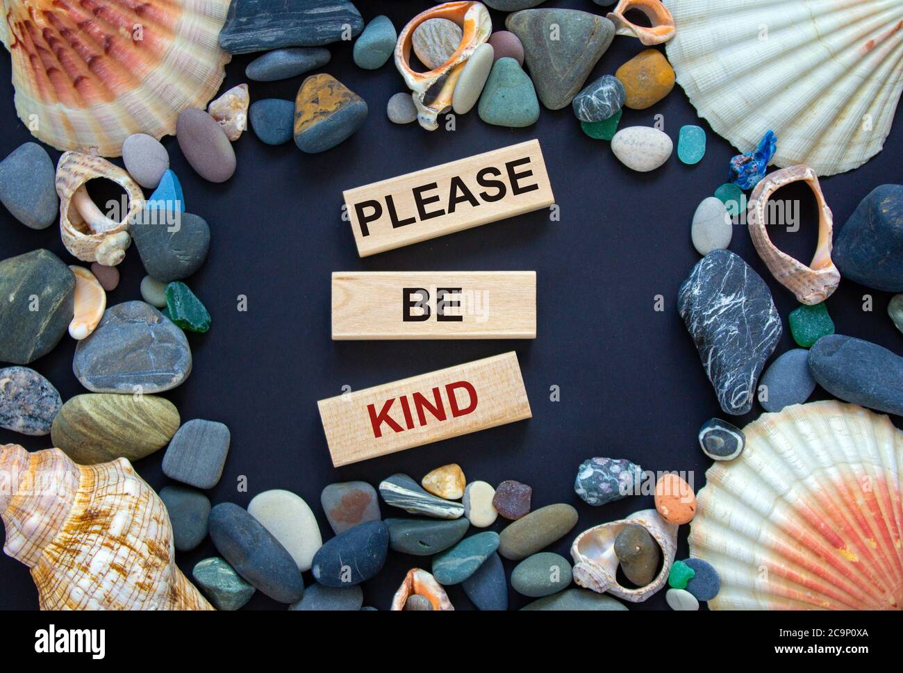 Text 'please be kind' on wooden blocks on a beautiful black background ...