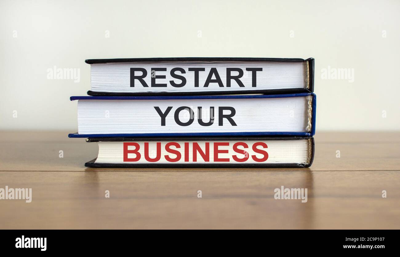 Books with text 'restart your business' on beautiful wooden table ...
