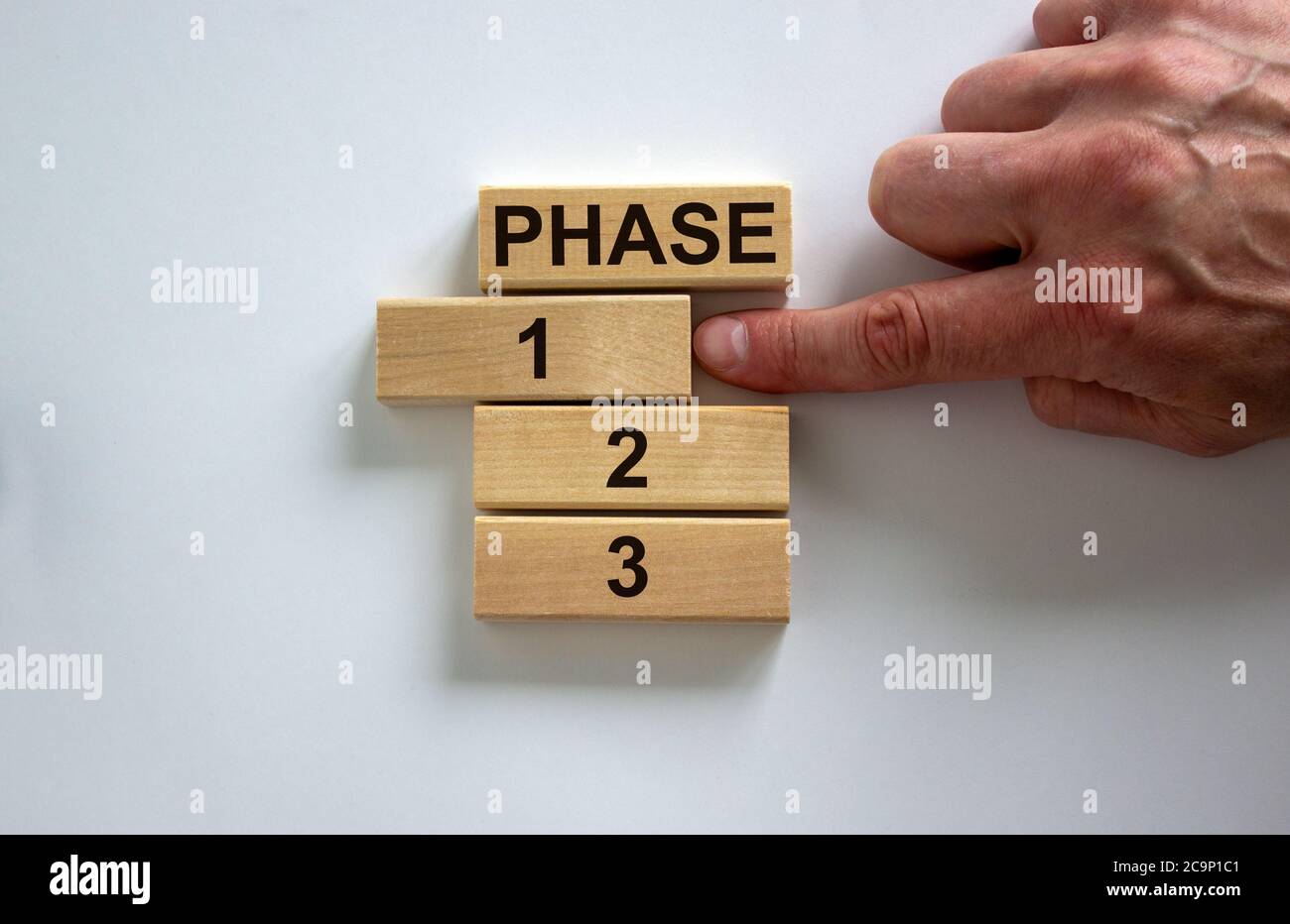 Wooden blocks form the words 'phase, 1, 2, 3,' on white background ...