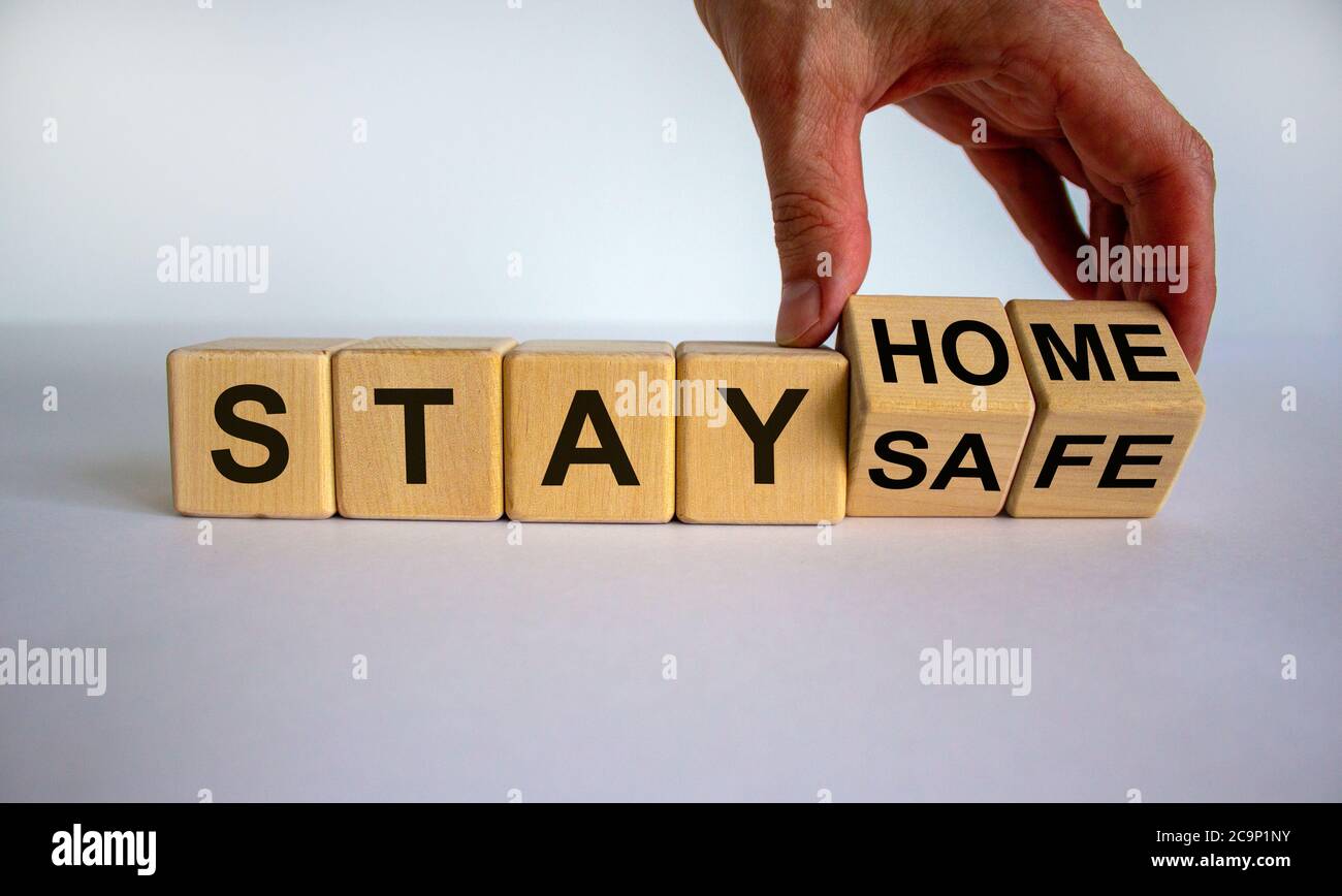Wooden cube form the expression 'stay home, stay safe'. Male hand ...