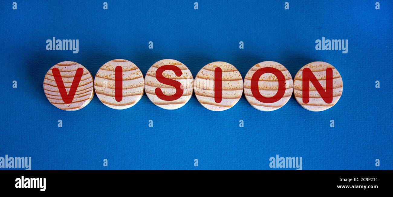 The word 'vision' on wooden circles on blue table. Beautiful background ...