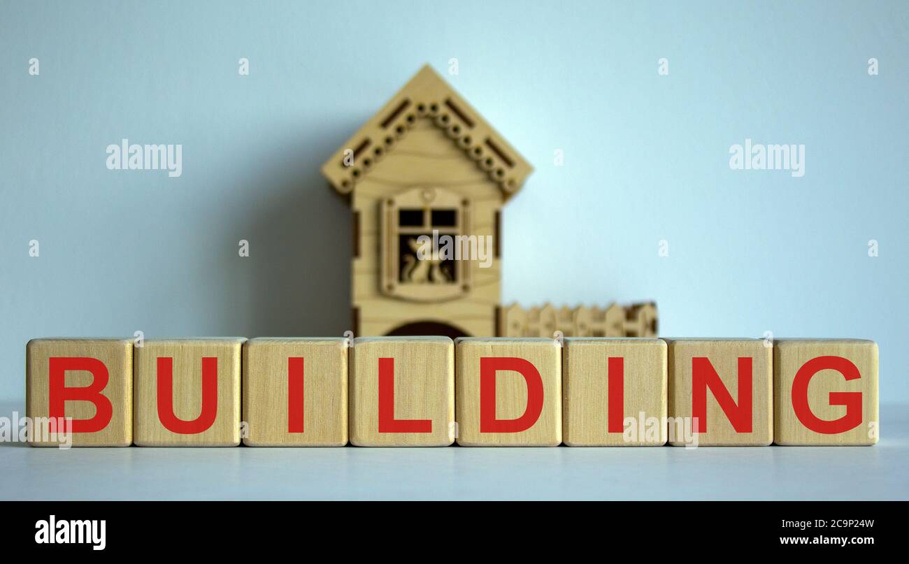Cubes form the word building in front of a miniature house Stock Photo ...