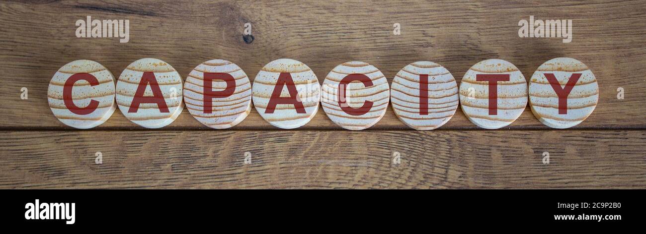 Wooden small circles with word capacity on wood background. Concept ...