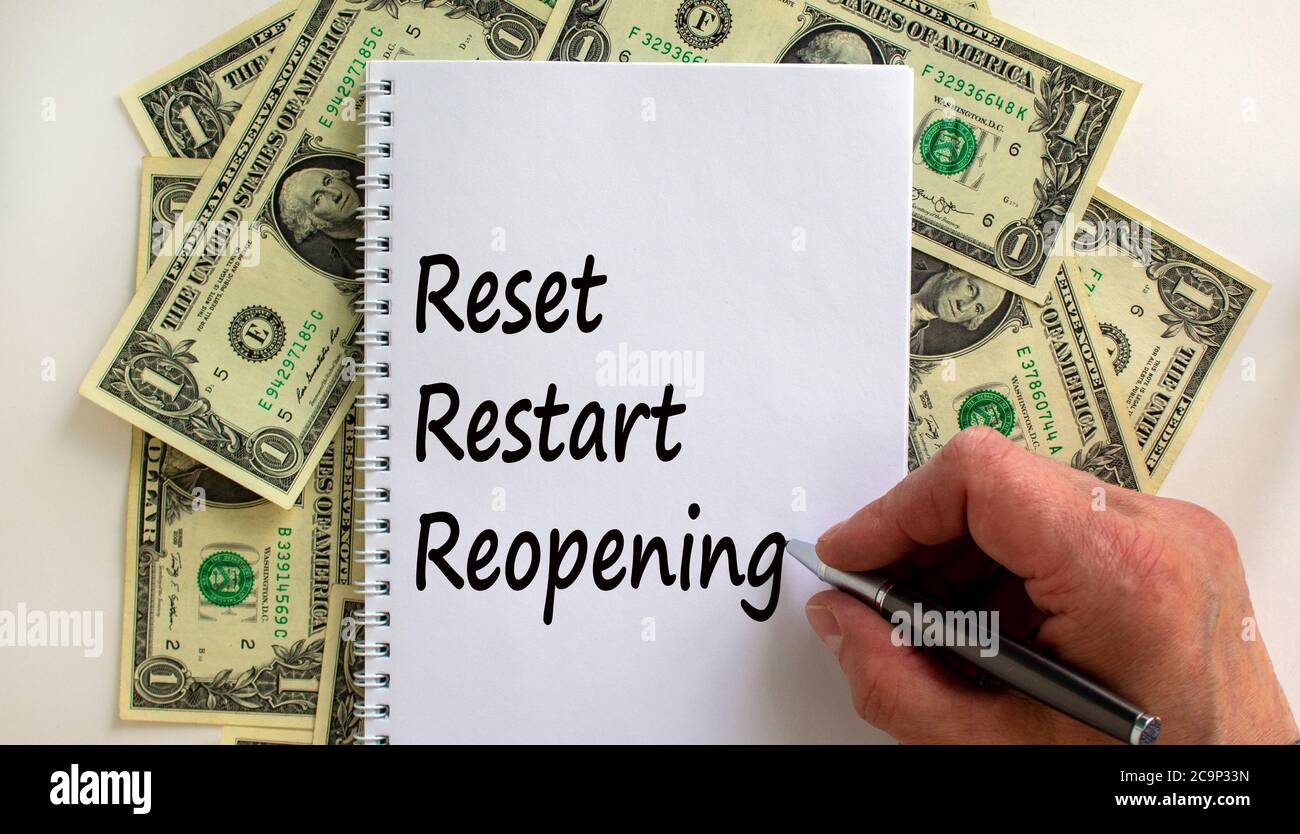 Male hand writing 'reset, restart, reopening' on white note, on white ...
