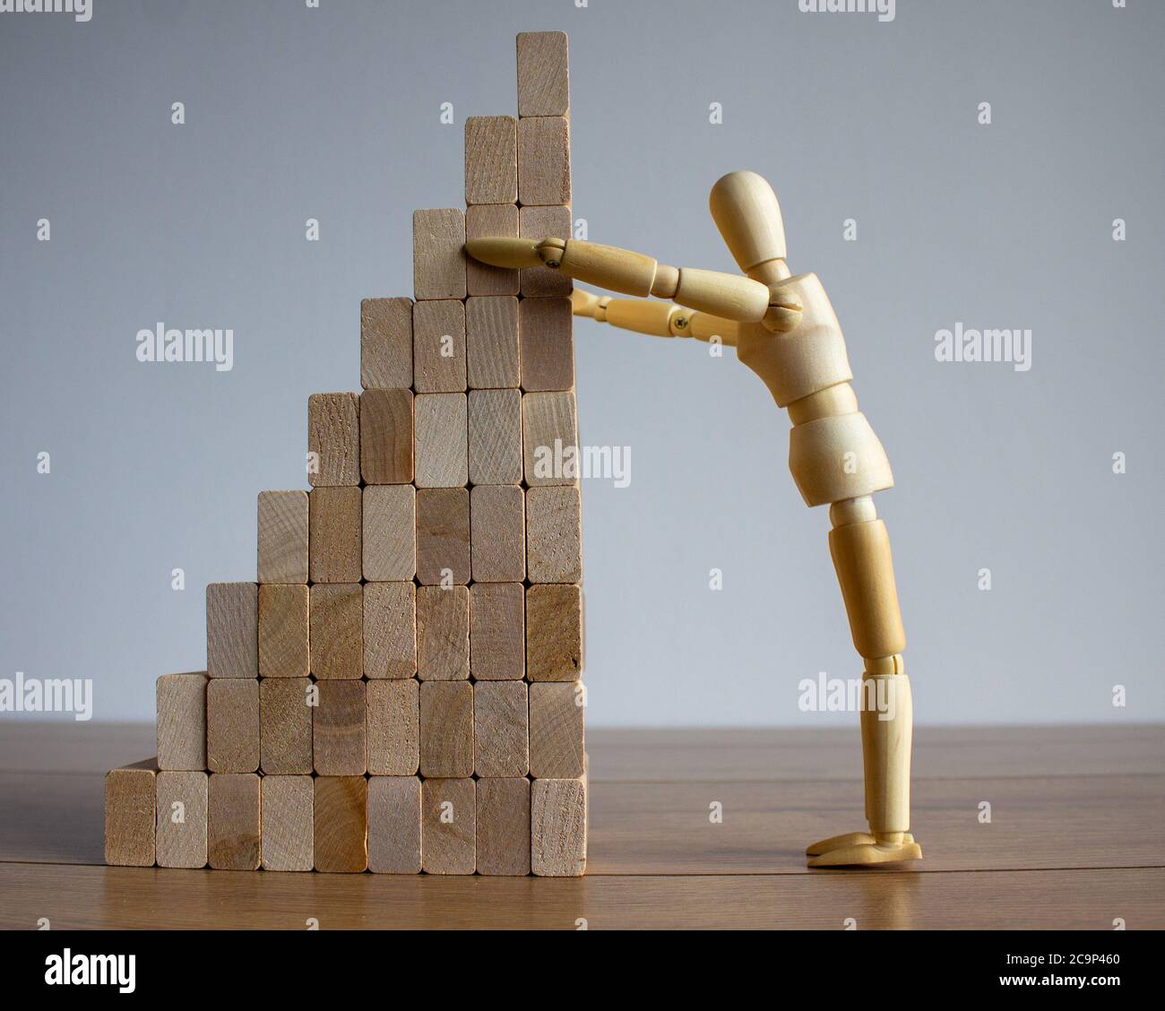 Wooden model of human put wooden blocks on the stack of wooden blocks ...