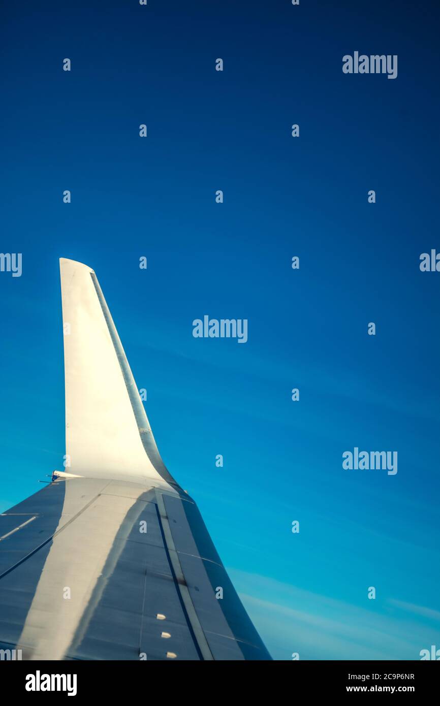 Commercial airplane winglet flying in a blue sky Stock Photo - Alamy