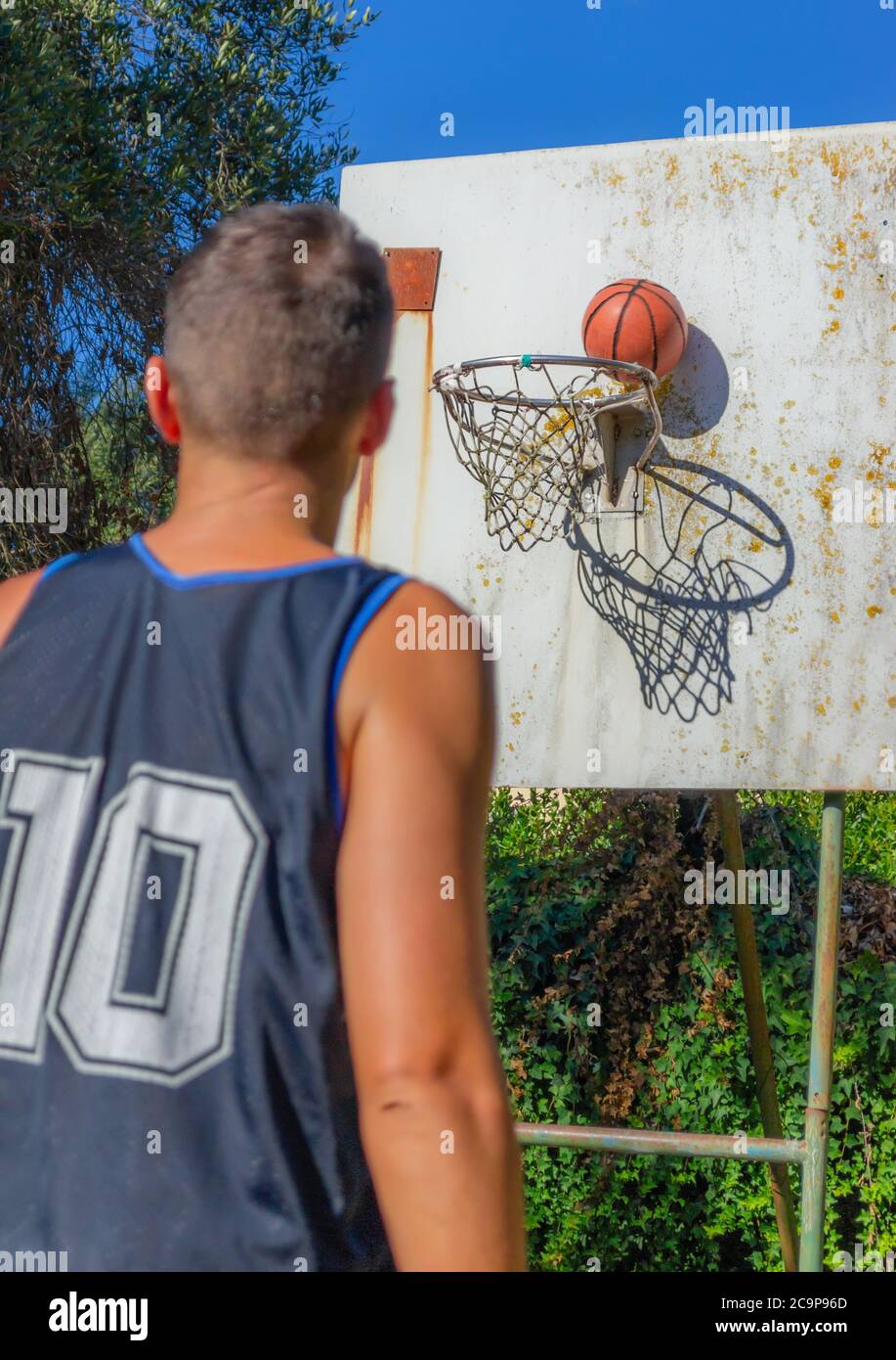 Basketball player on a backyard basketball court in summer Stock Photo ...