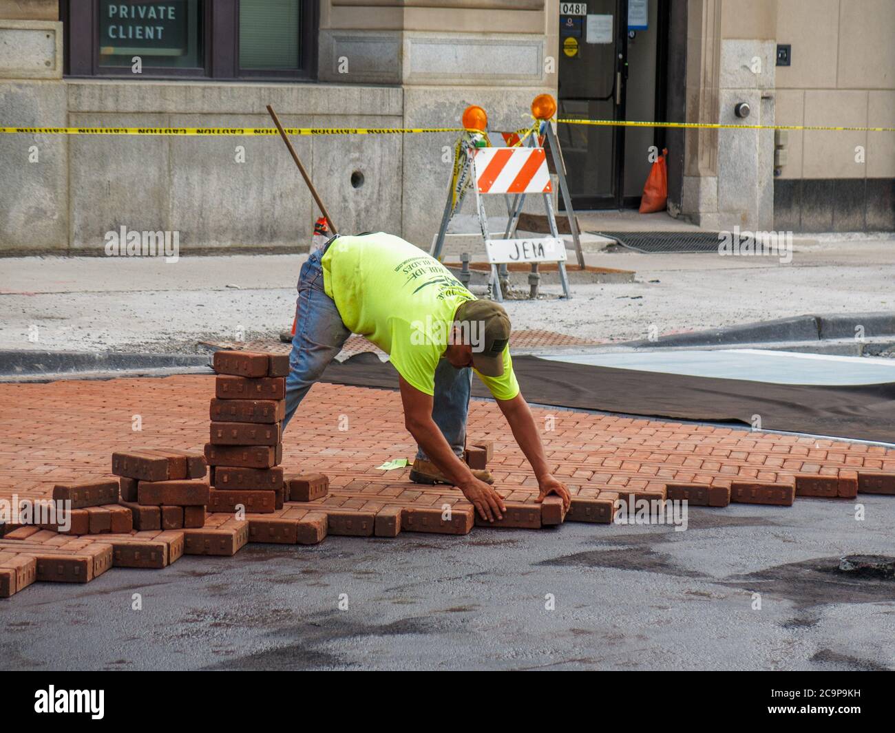 Construction worker laying brick pavement during Lake Street ...
