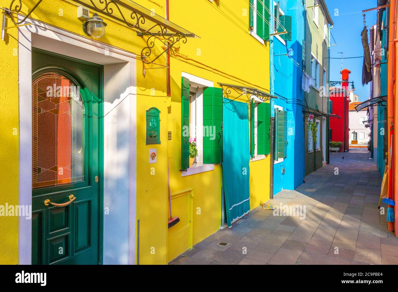 Narrow alley in world famous Burano, Italy Stock Photo - Alamy