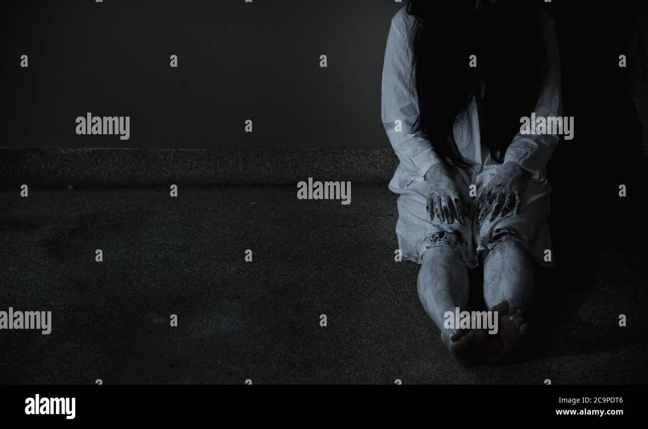 Woman ghost horror sitting near wall in the house, halloween concept ...