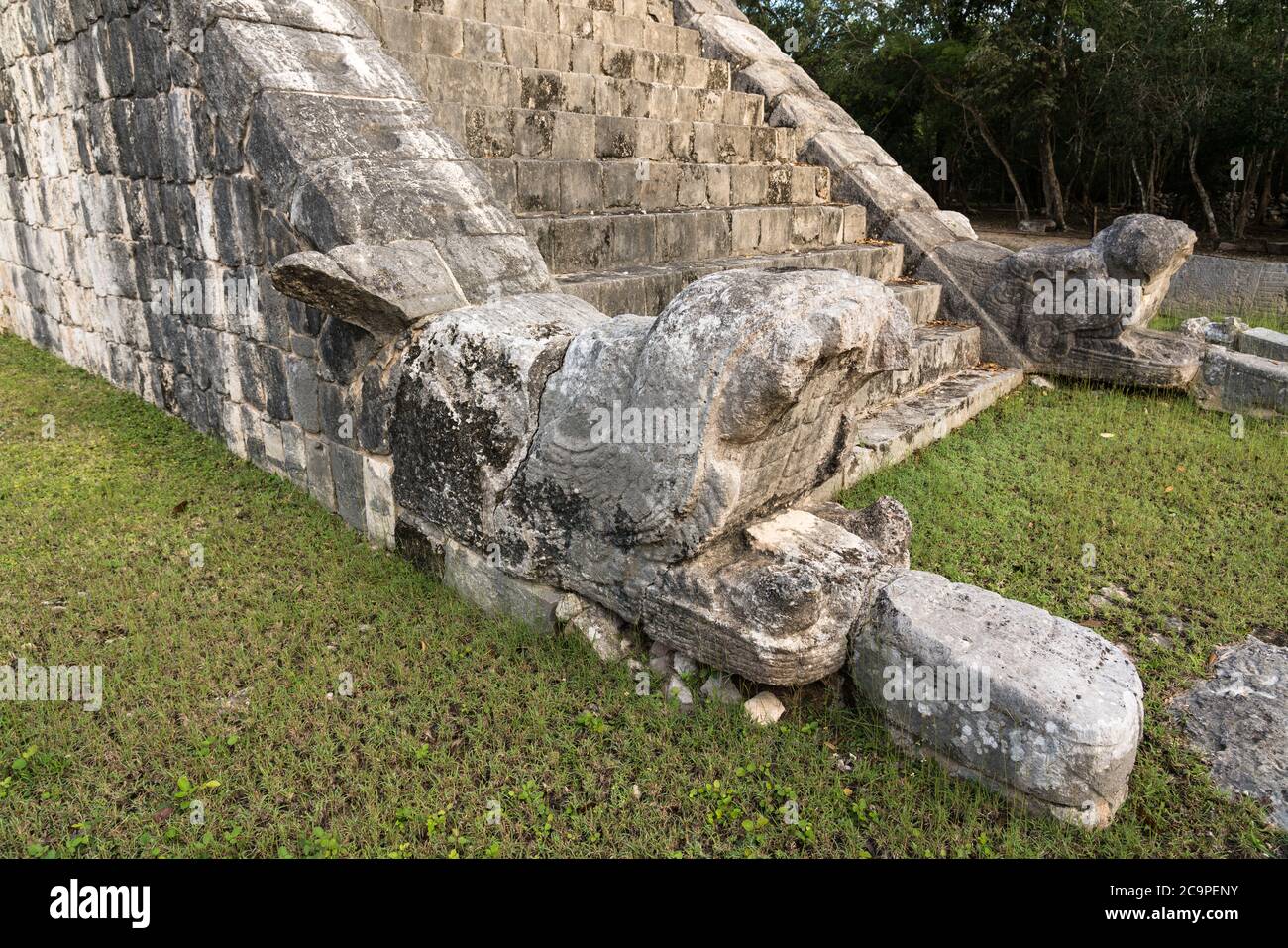 Carved stone serpent heads at the base of the Ossuary or Osario, the ...