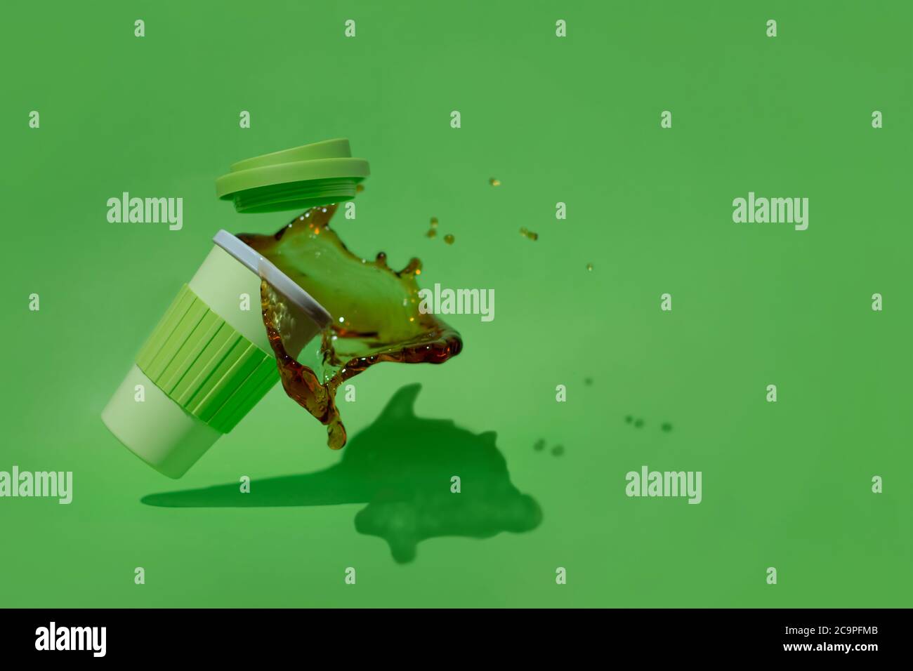 Plastic cup of coffee falling and spilled on a green background Stock ...