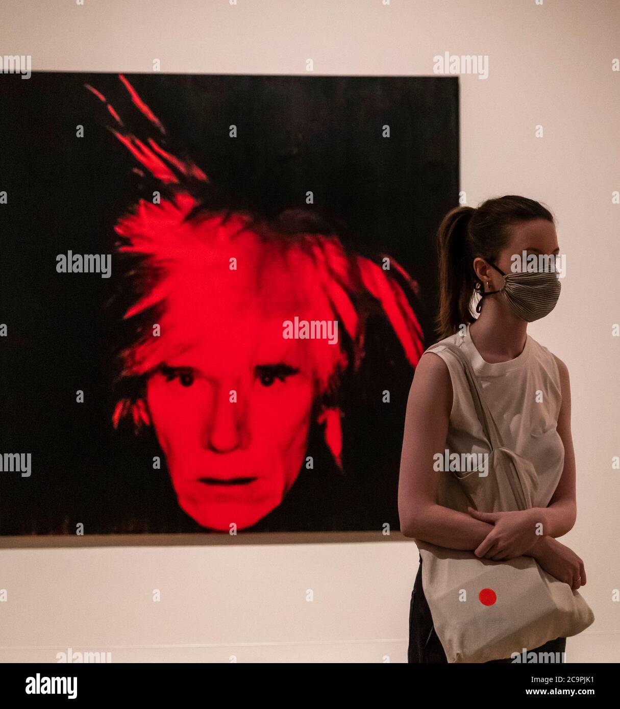 London, Britain. 1st Aug, 2020. A visitor wearing a face mask walks by ...