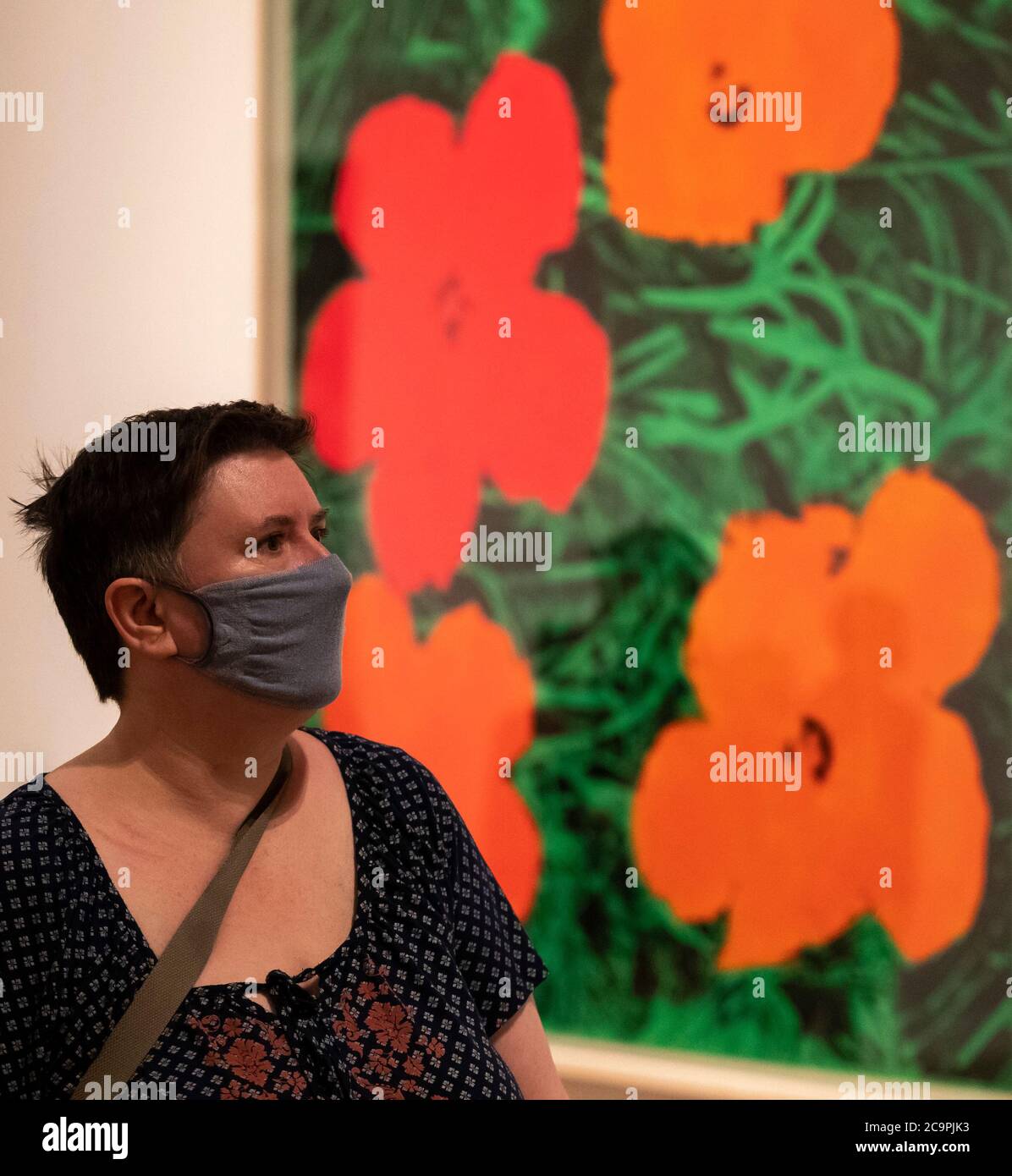 London, Britain. 1st Aug, 2020. A visitor wearing a face mask walks by ...