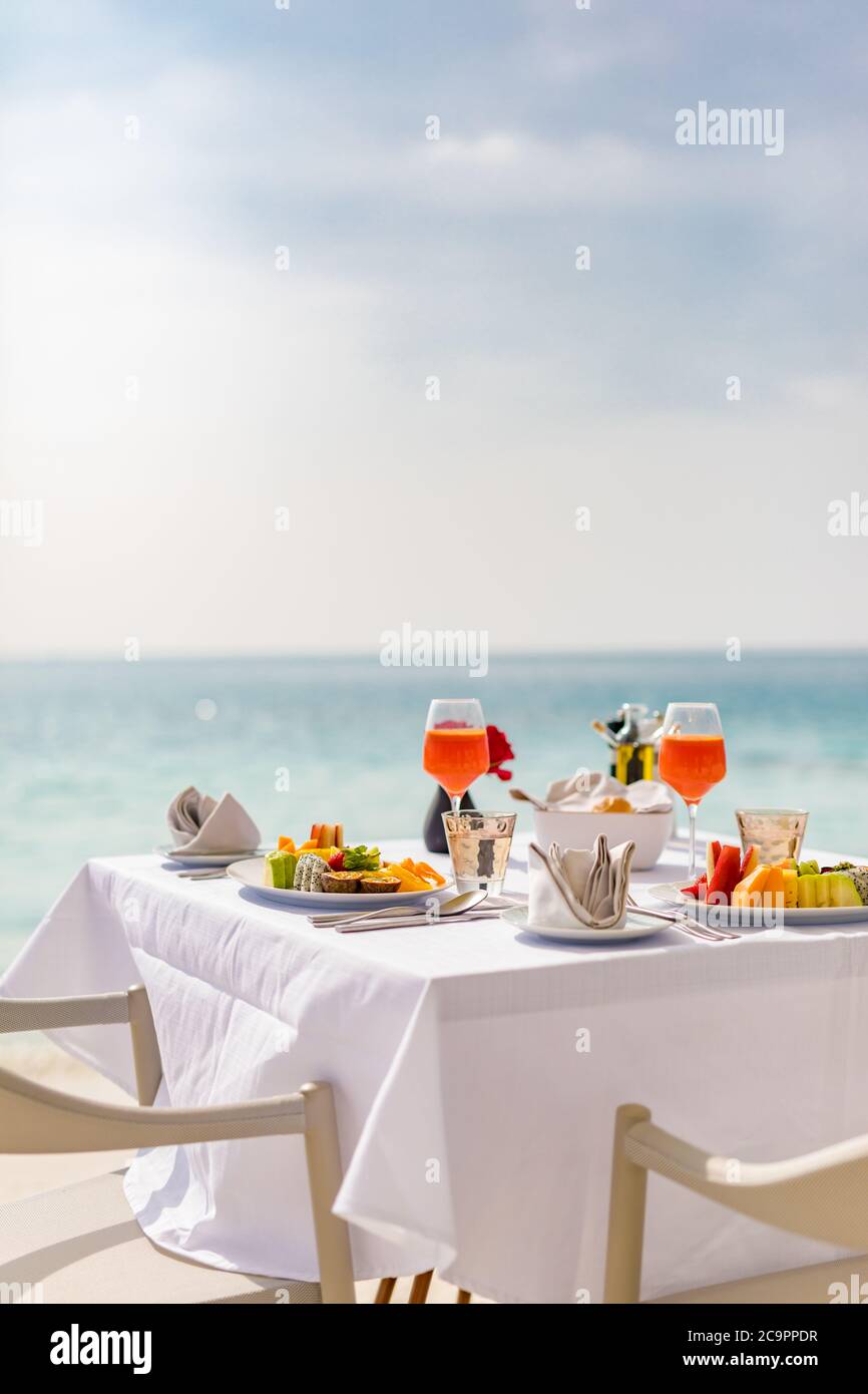 Breakfast on the beach at hotel or resort by the sea in summer season ...