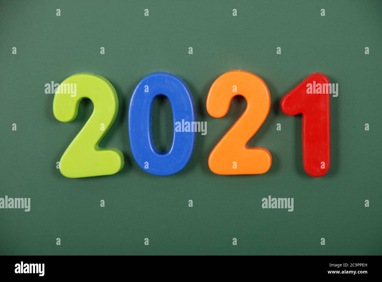 2021 year written in bright plastic magnetic letters stuck on a ...