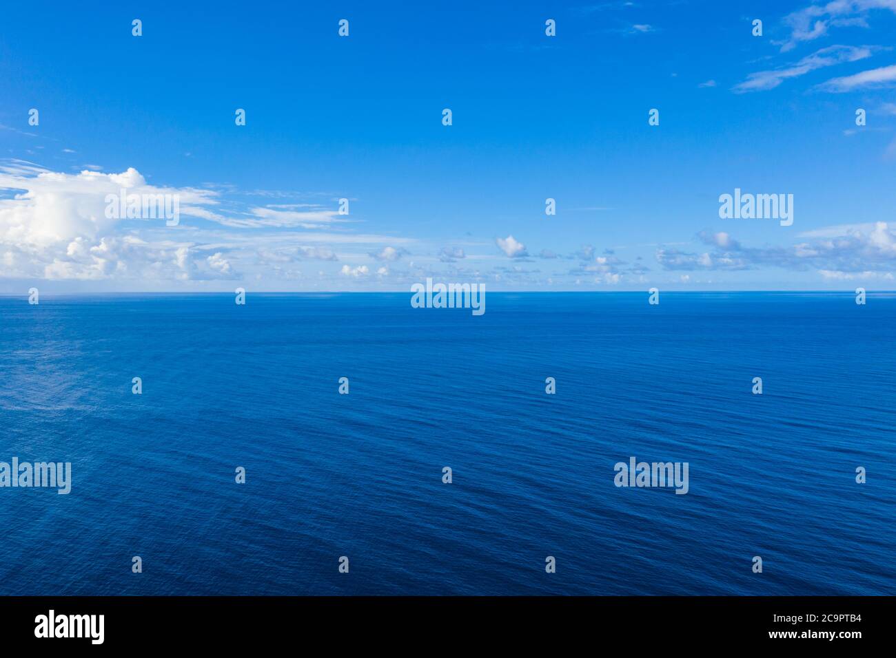 Seascape with sea horizon and almost clear deep blue sky background ...