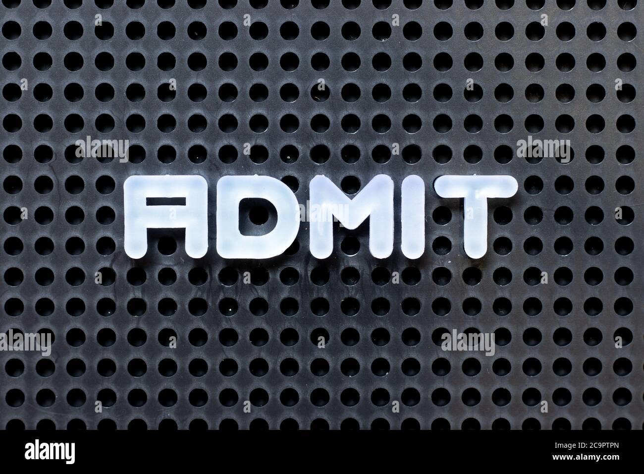 White color alphabet with word admit on black pegboard background Stock ...