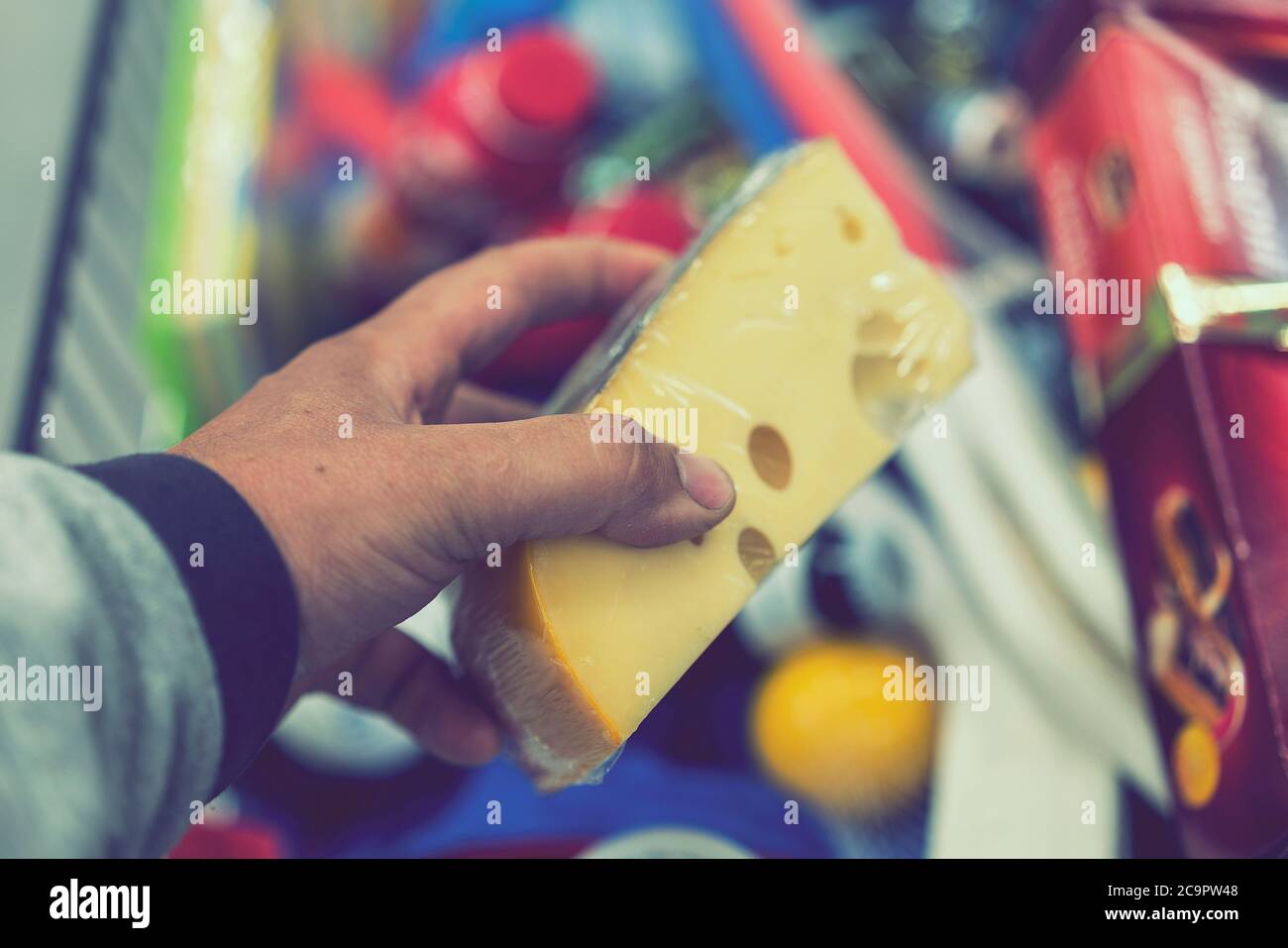 Male hand holds cheese in a supermarket. toned Stock Photo - Alamy