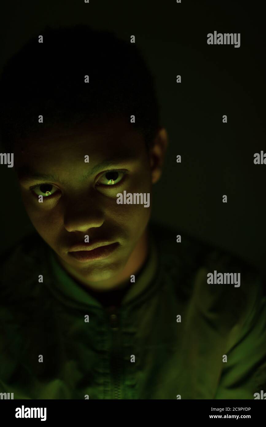 Portrait of young boy in dark room Stock Photo - Alamy