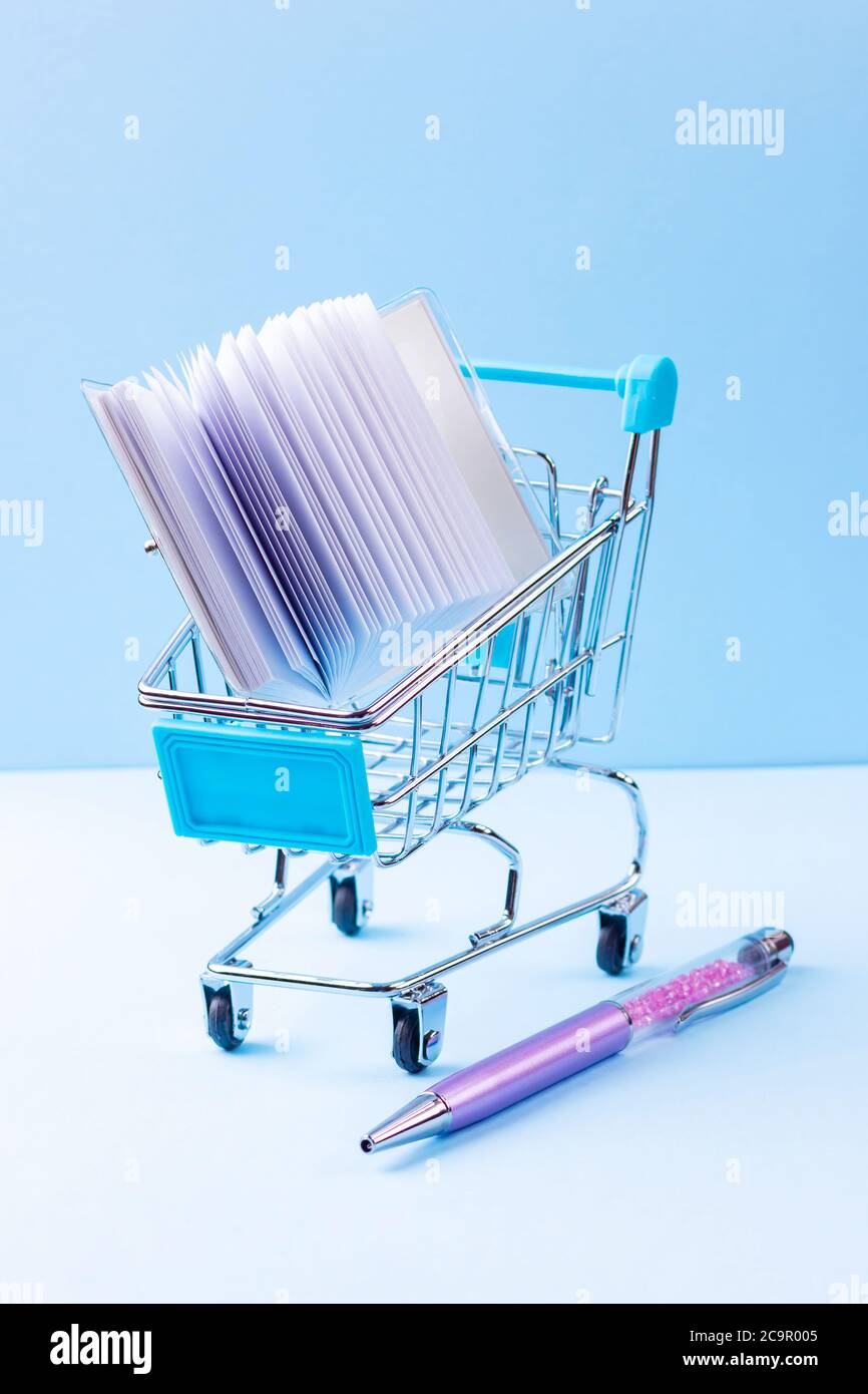Shopping cart with school supply. School notepad with holographic cover ...
