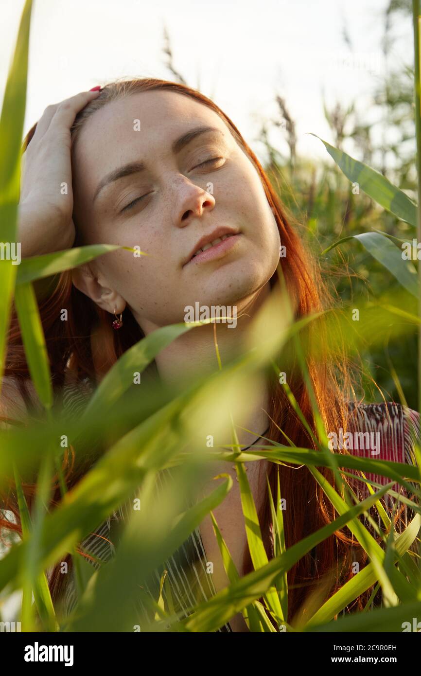 sensual red hair young woman in reed with closed eyes Stock Photo - Alamy