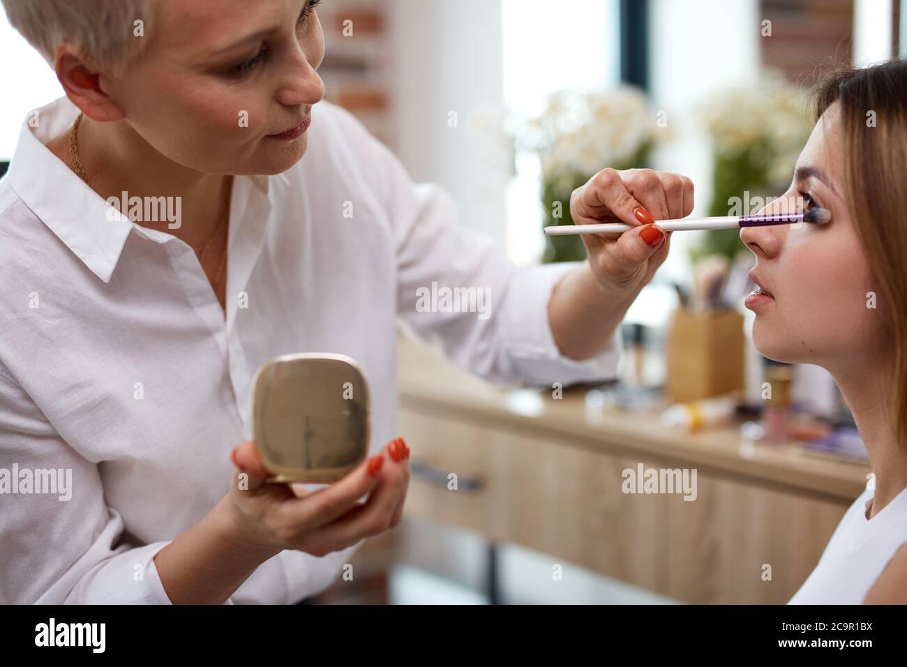 famous talented make-up artist doing make-up on model, she uses brushes ...