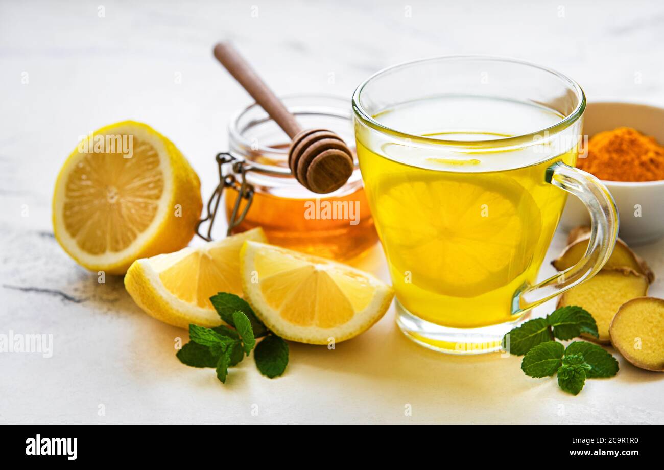 Energy tonic drink with turmeric, ginger, lemon and honey on a white ...