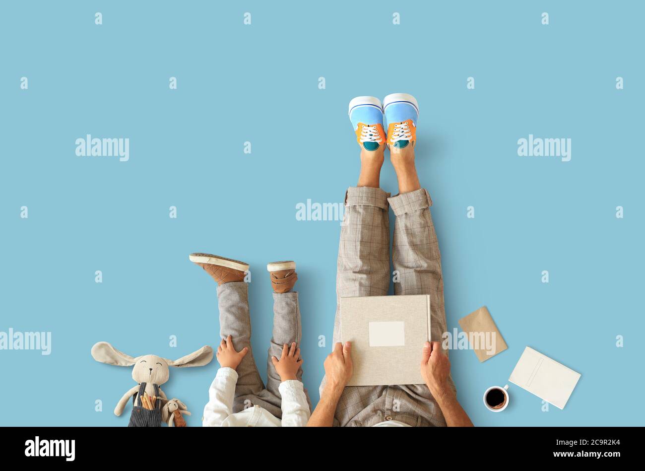 Father and young son sit and read a book Stock Photo - Alamy