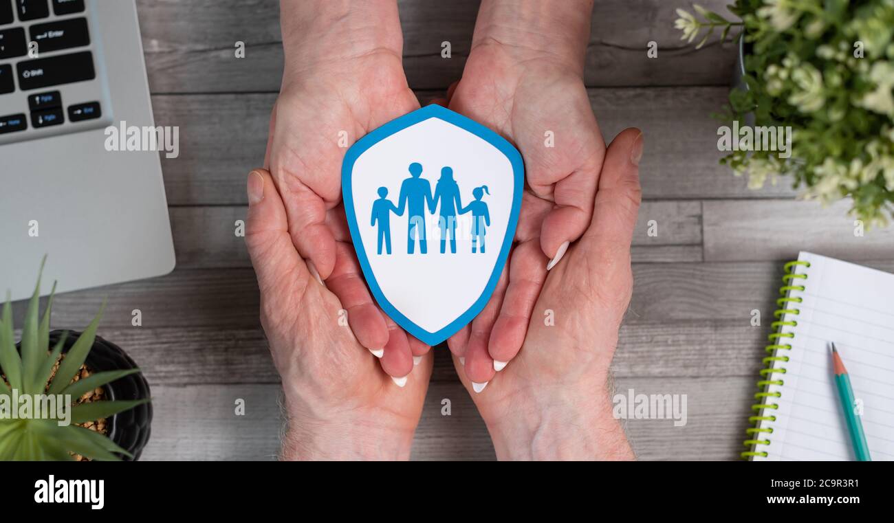 Concept of family insurance with paper shield in hands Stock Photo - Alamy