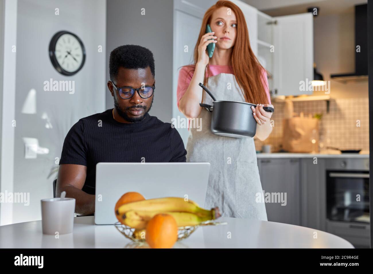 busy man work on laptop, redhead female talk on phone,she listens to ...