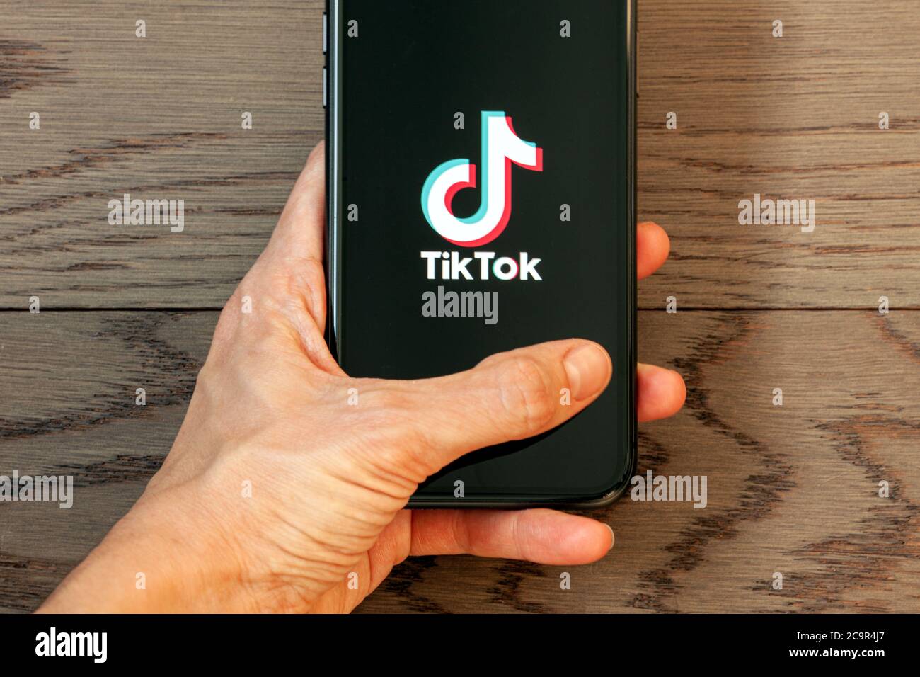 TikTok application icon on Apple iPhone 11 screen close-up. Hand ...