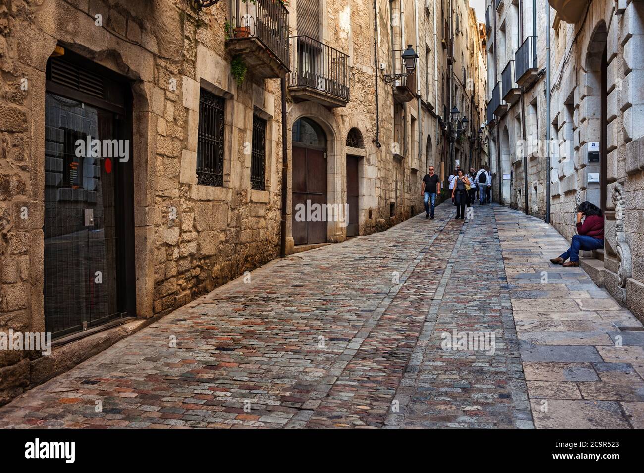 Cobbled street and stone buildings in Old Town of Girona city in ...