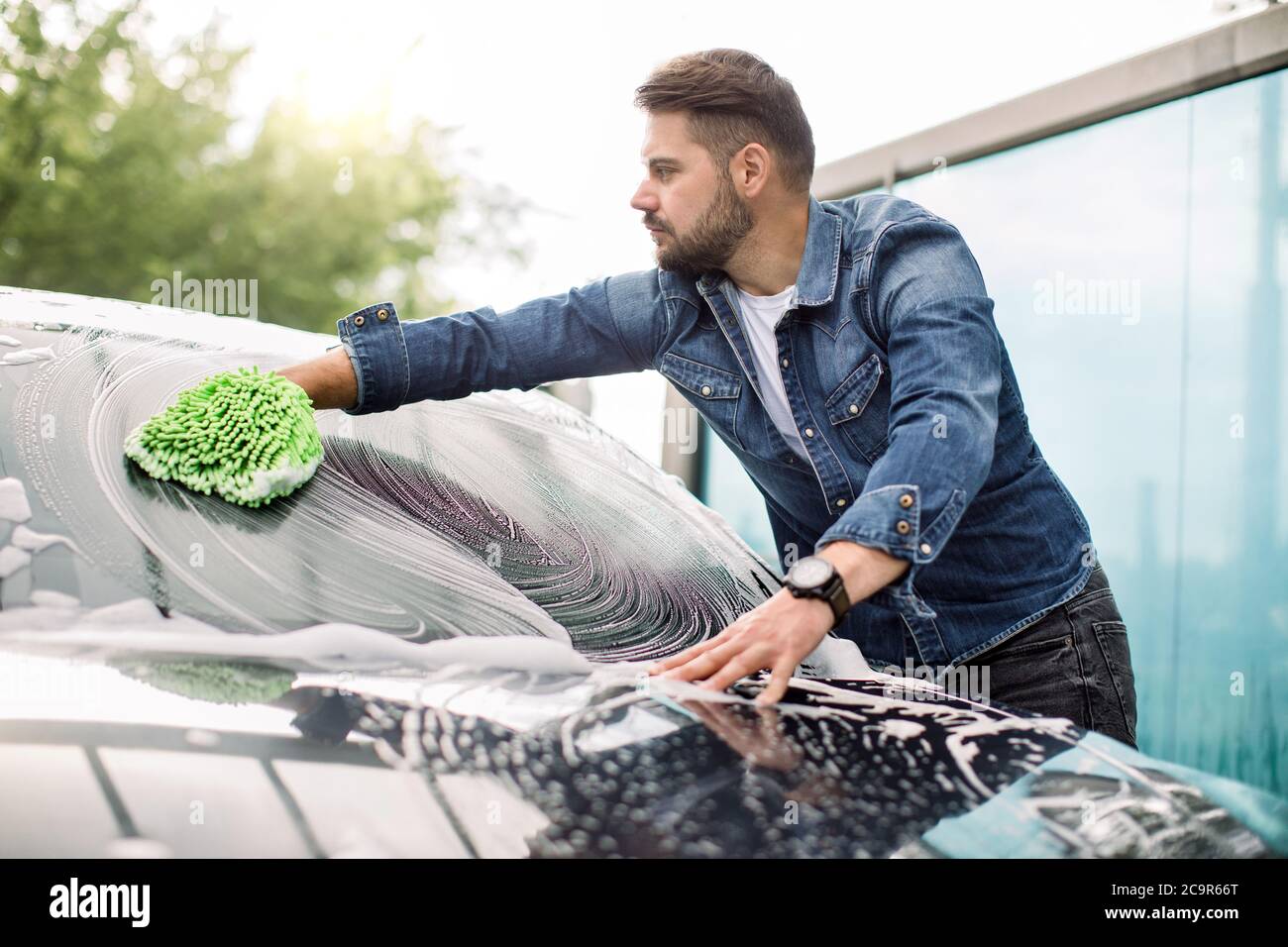 Horizontal view of car cleaning at self wash service outdoors. Handsome ...