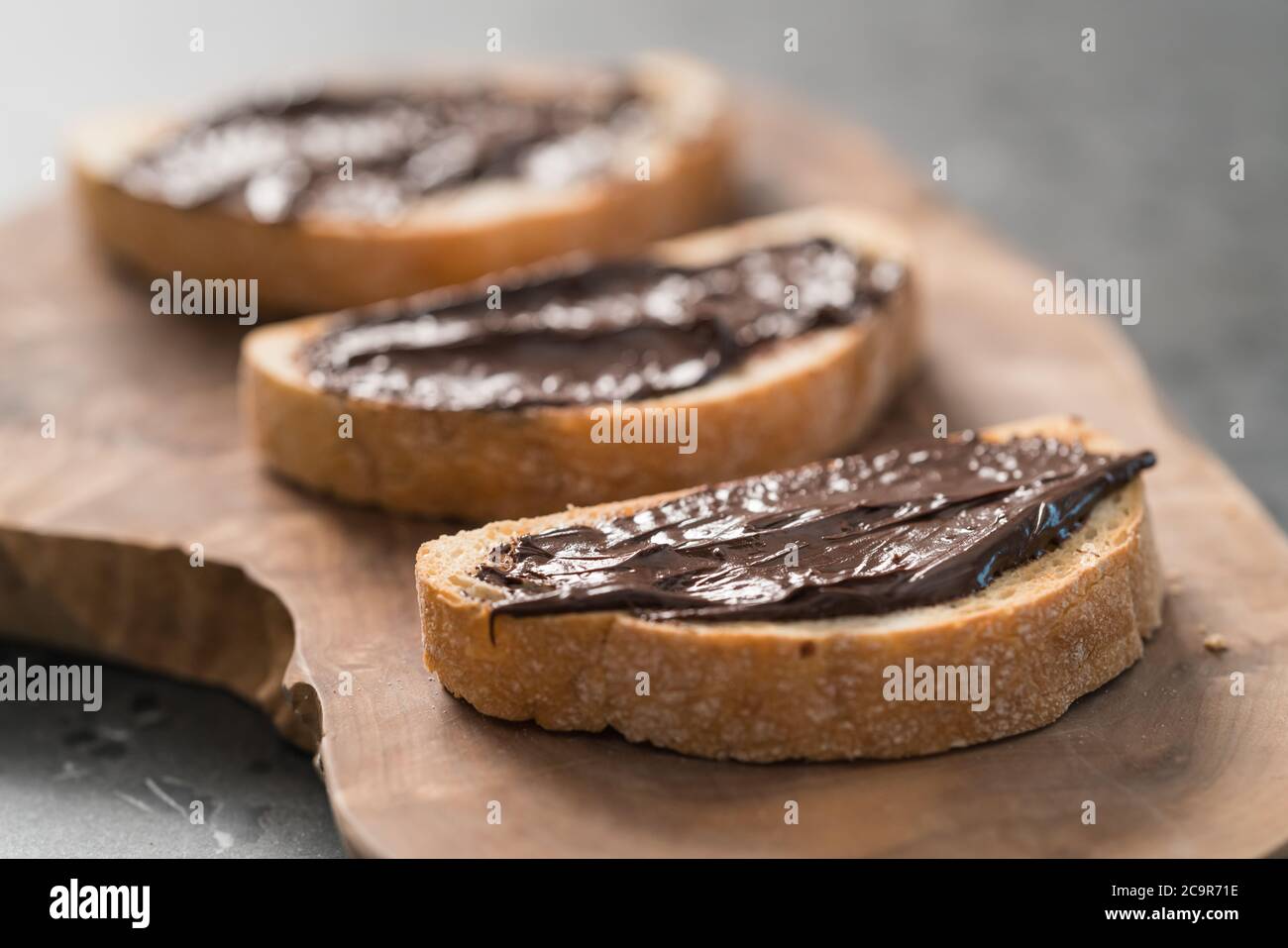 Rustic ciabatta with organic chocolate cream on olive wood board Stock ...