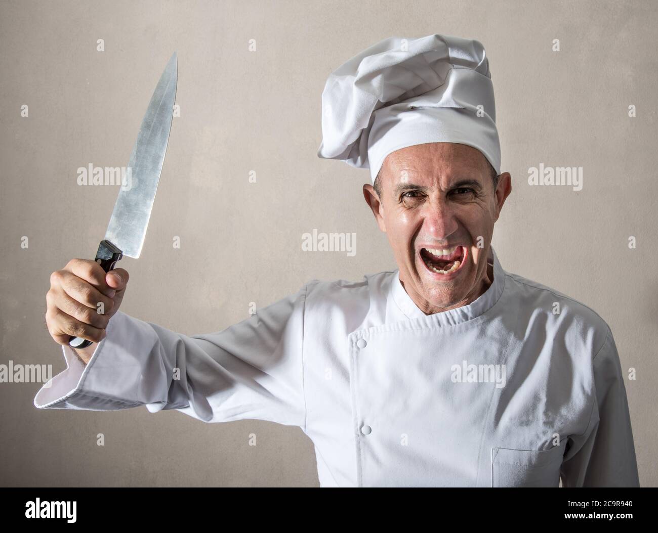 an aggressive cook with knife Stock Photo - Alamy