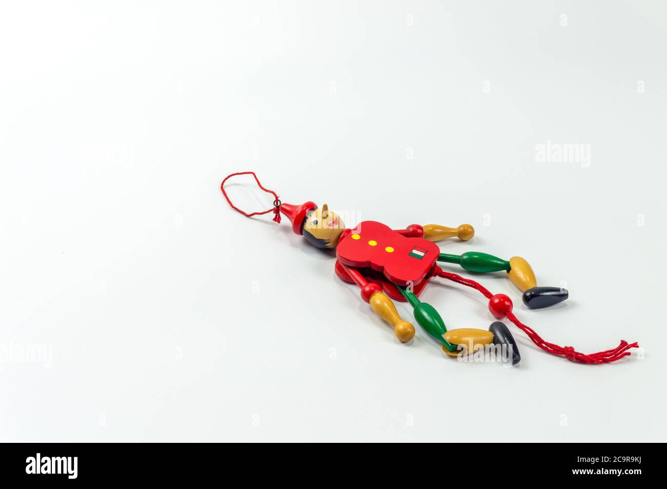 The wooden doll toy has a red-green color on a white background Stock ...