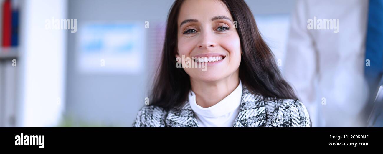 Beautiful satisfied employee smiling at workplace Stock Photo - Alamy