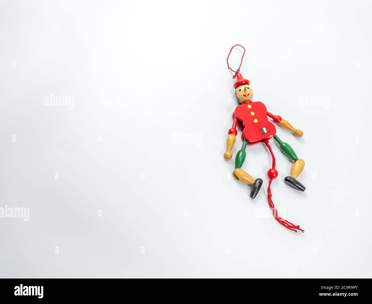 The wooden doll toy has a red-green color on a white background Stock ...