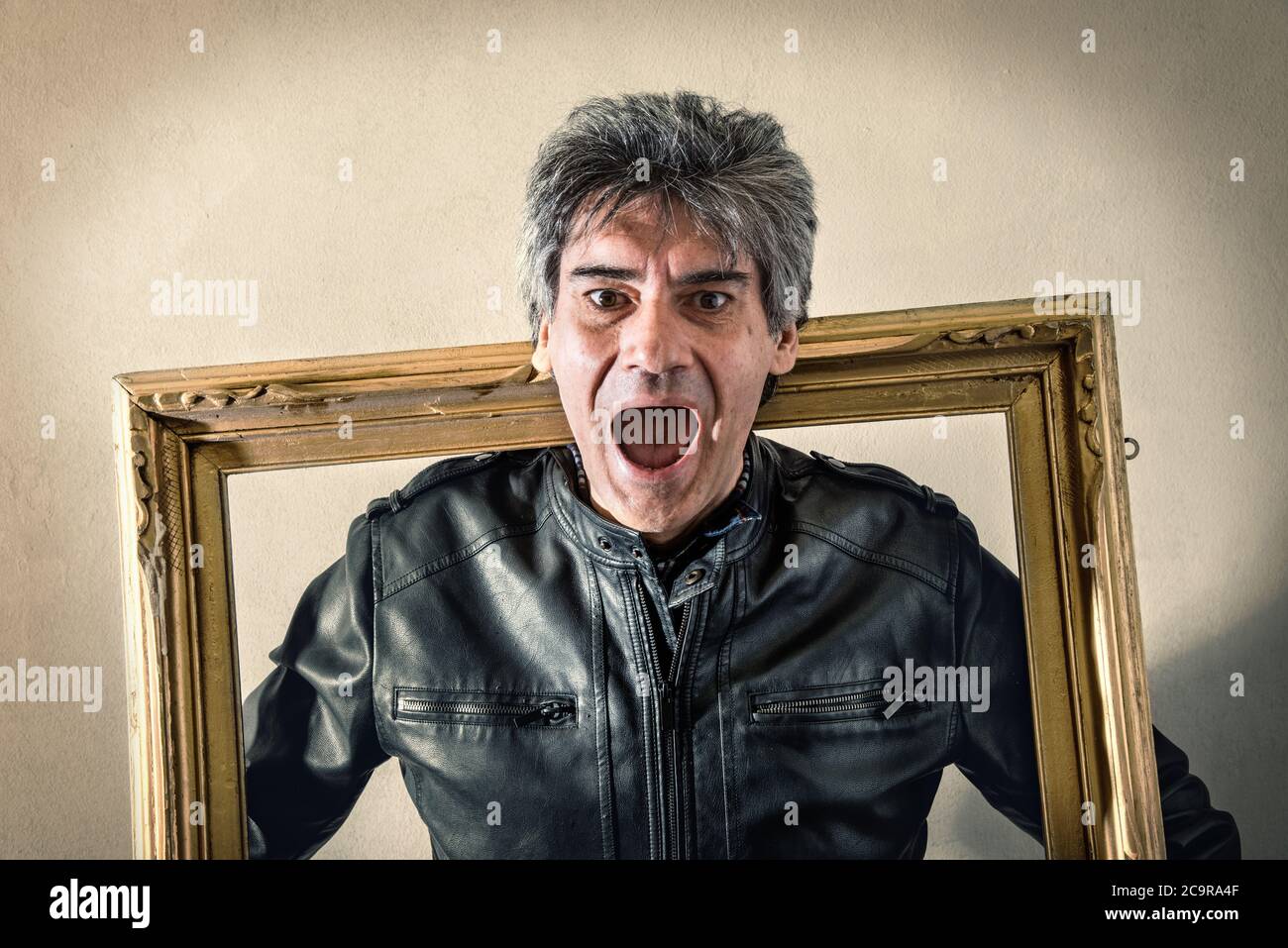 a Man screaming with a frame at the neck Stock Photo - Alamy