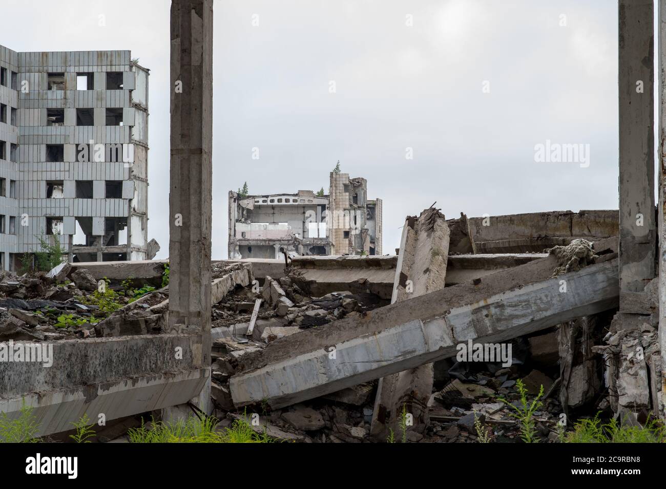 A large destroyed building with a pile of gray concrete debris and ...