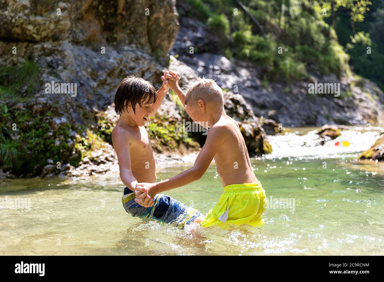 Two boys playing in river Stock Photo - Alamy
